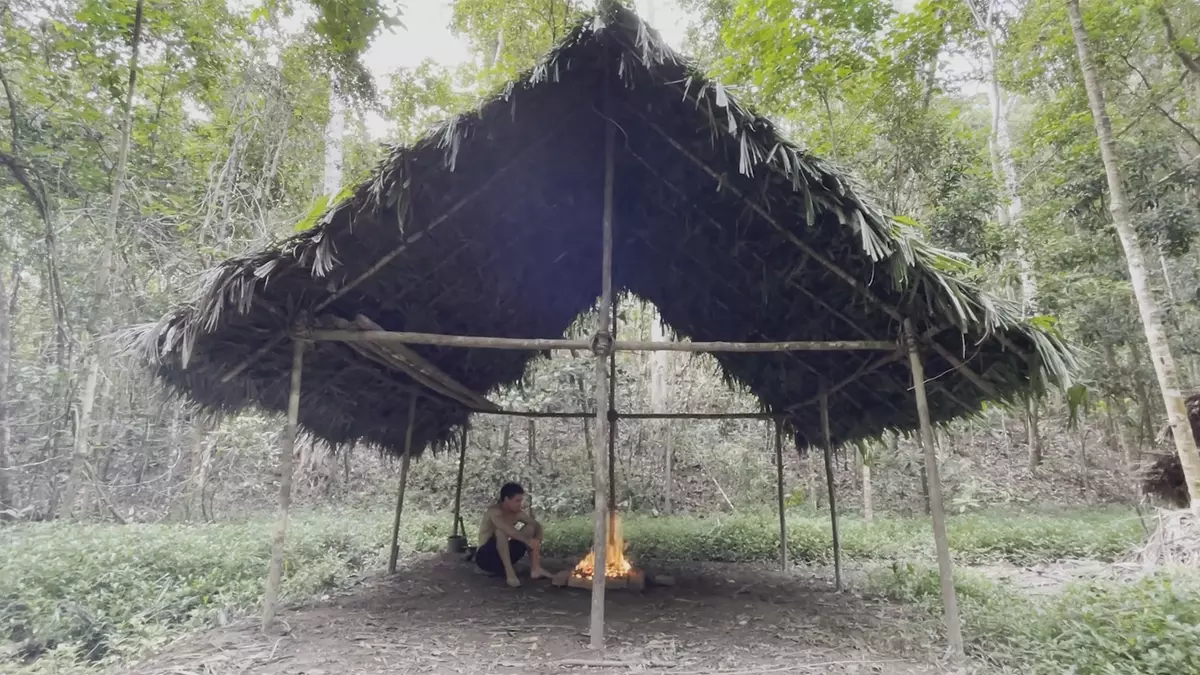 Vídeo de tecnologia primitiva mostrando um homem fazendo uma fogueira em uma cabana