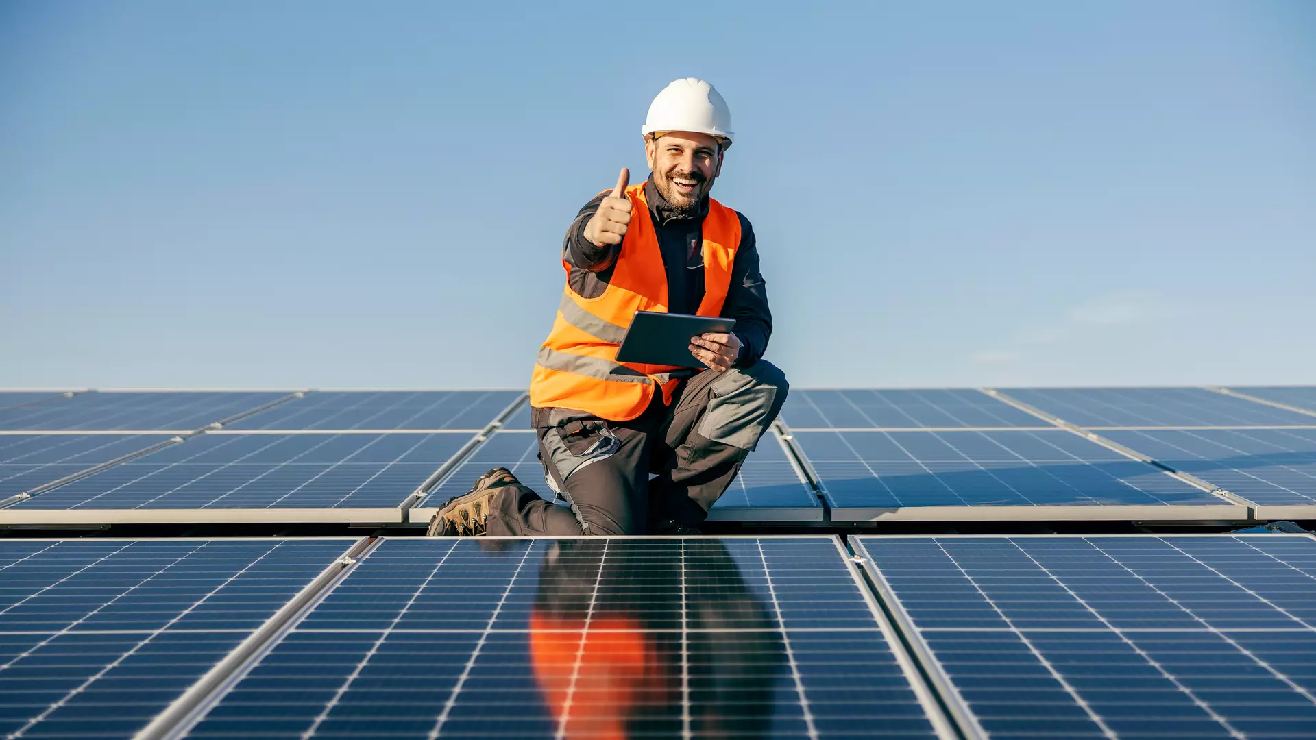 Střešní solární panely a muž dává palec nahoru