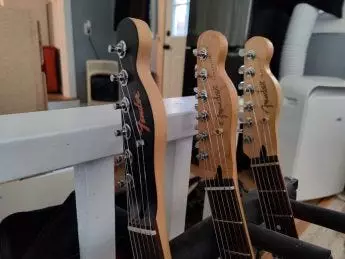 Vzorec kamere OnePlus 9 Pro: Bližnji posnetek treh glav kitare Fender Telecaster, posnet v zaprtih prostorih z glavno kamero