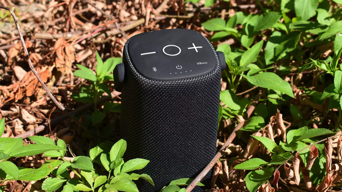 Speaker Tribit Stormbox Pro di beberapa daun dan kotoran.