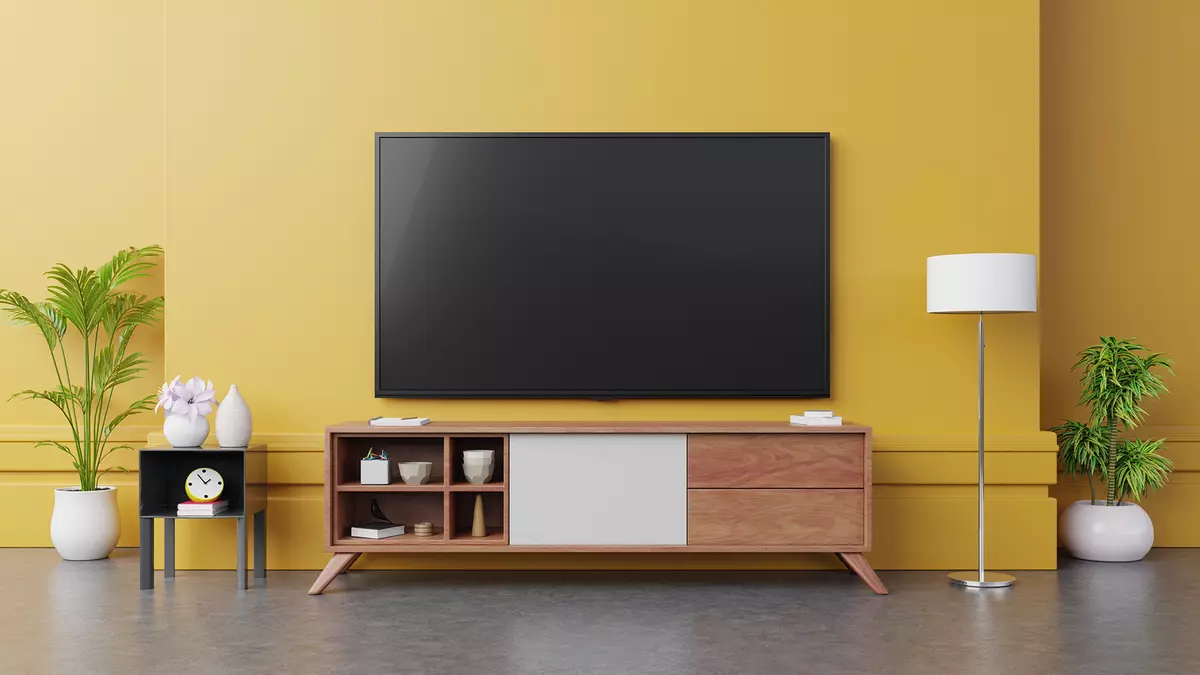 Televizorius tvirtinamas prie svetainės sienos.