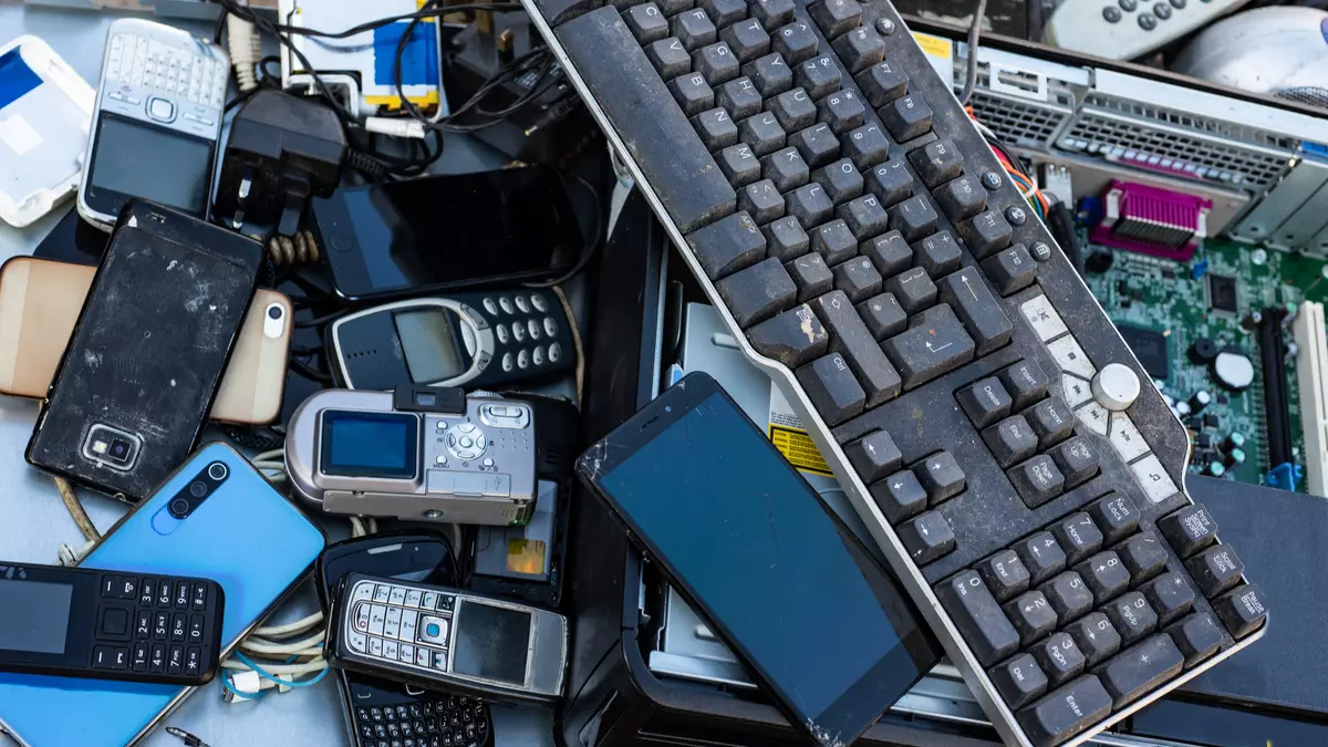મિશ્રિત ઈલેક્ટ્રોનિક કચરાના ઢગલા, જૂના તૂટેલા કોમ્પ્યુટરના ભાગો અને સેલ ફોન પર બંધ કરો
