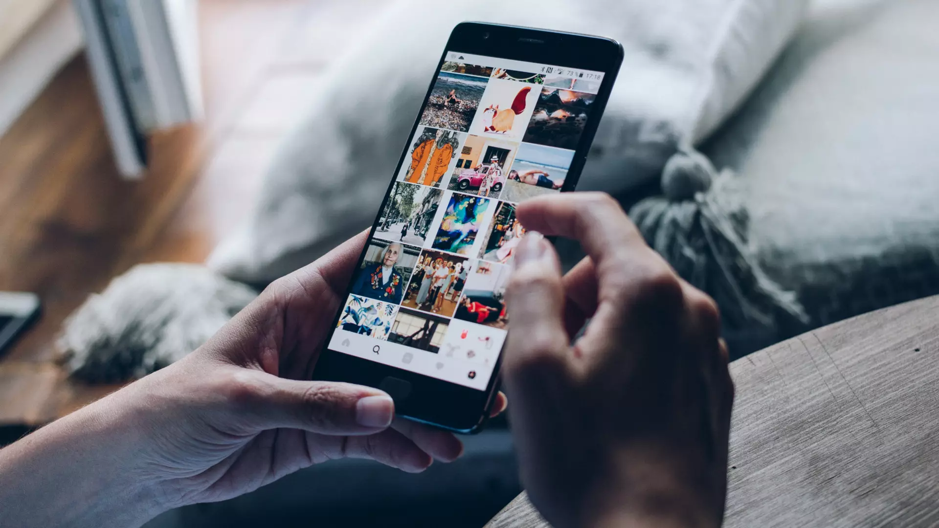 年轻女子拿着智能手机与 Instagram 应用程序的搜索页面屏幕。 Instagram 是最大和最受欢迎的照片社交网络。