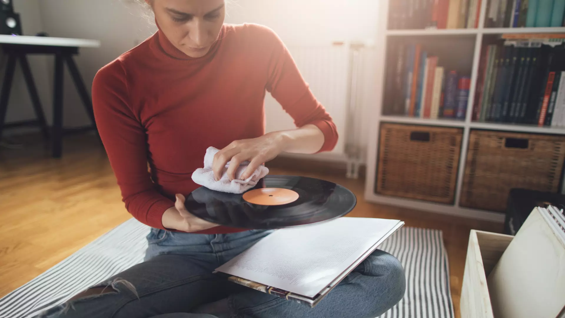年轻的时髦人士从他们的黑胶唱片收藏中清理灰尘