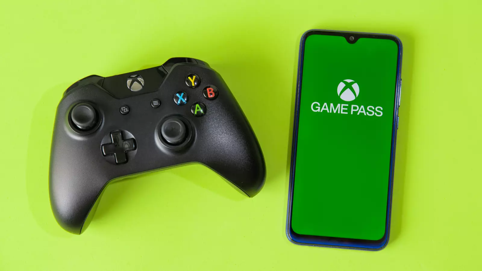 កម្មវិធី Xbox Game Pass នៅលើស្មាតហ្វូននៅក្បែរឧបករណ៍បញ្ជា Xbox One