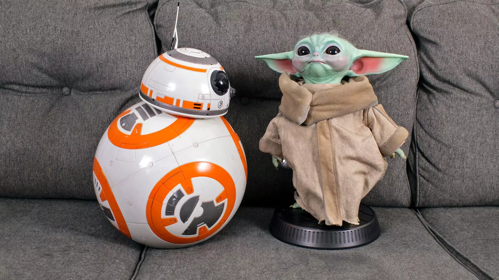 Baby Yoda naast een grote BB-8 replica