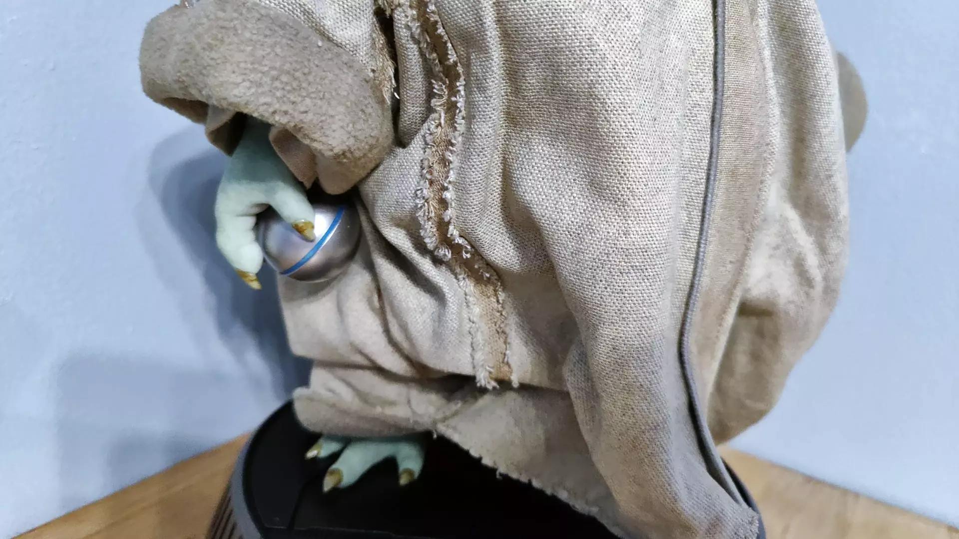 Een close-up van de hand van Baby Yoda, met een ronde pookknop.