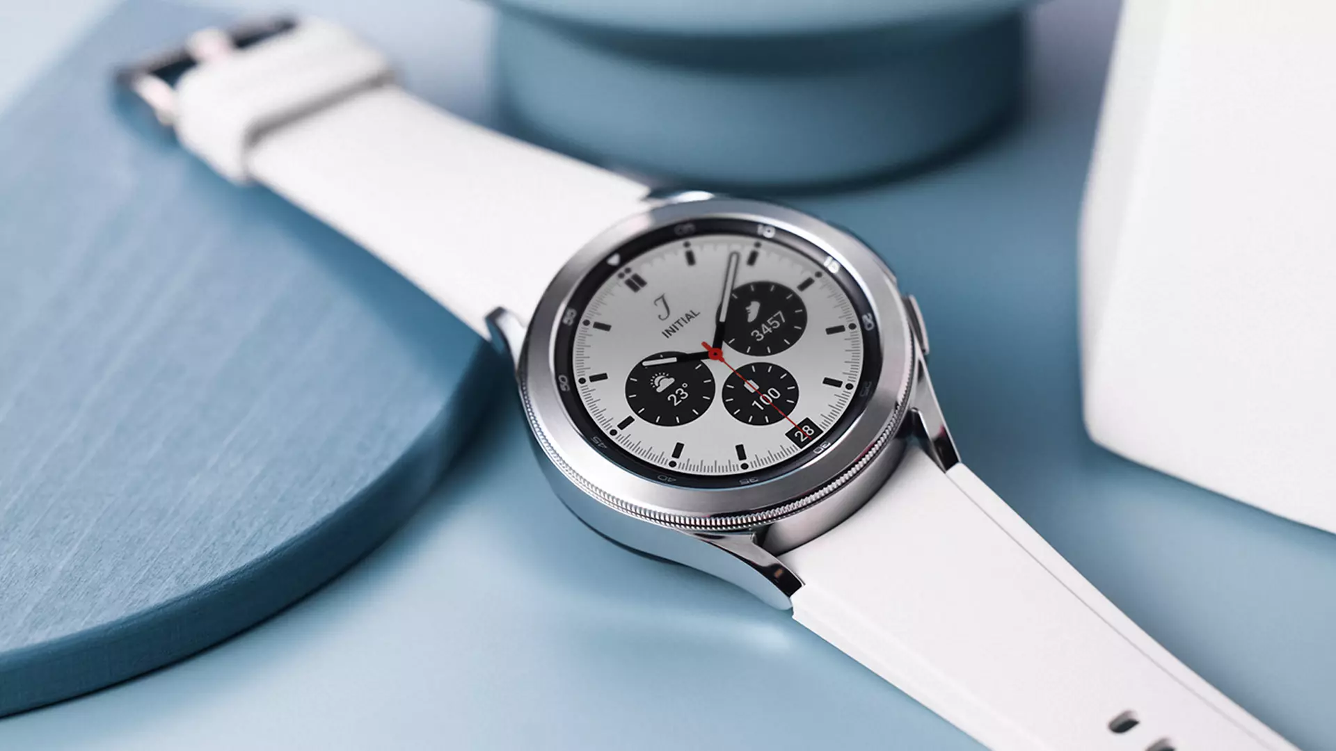 Samsung Galaxy Watch 4 Classic თეთრ ფერში ლურჯ ფონზე.