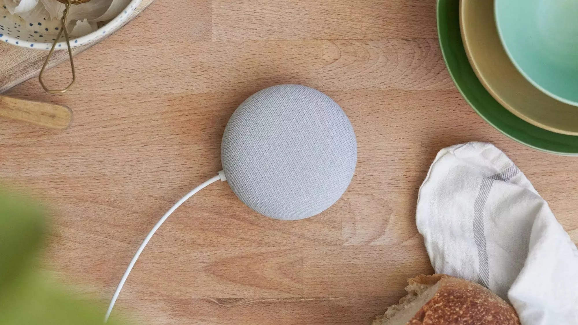 Паметен звучник на Google Nest Mini на маса.