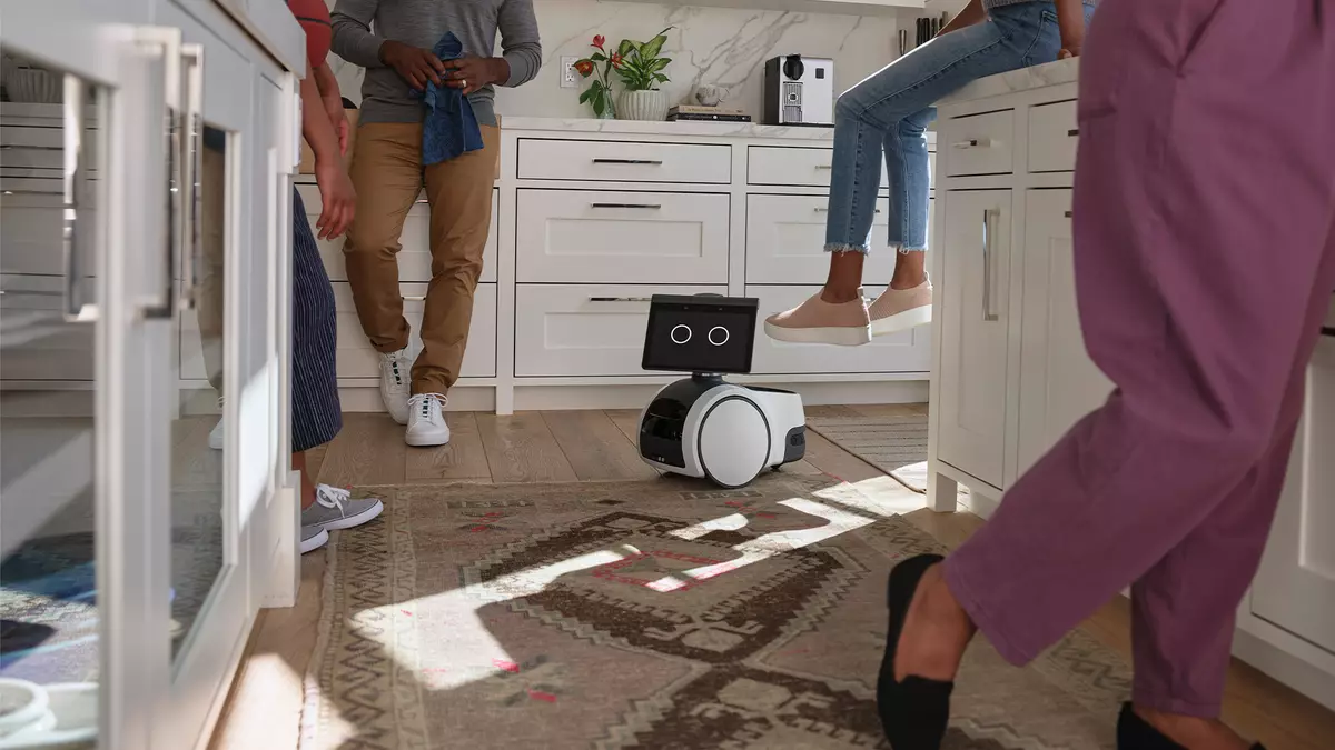 Amazon Astro rolando por um grupo de pessoas em uma cozinha.