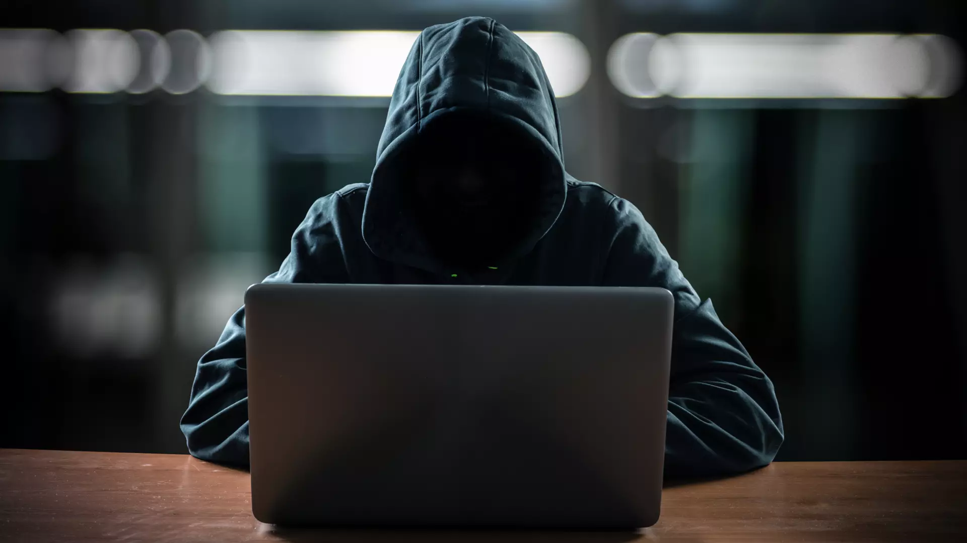 Haker przed swoim komputerem. Ciemna twarz