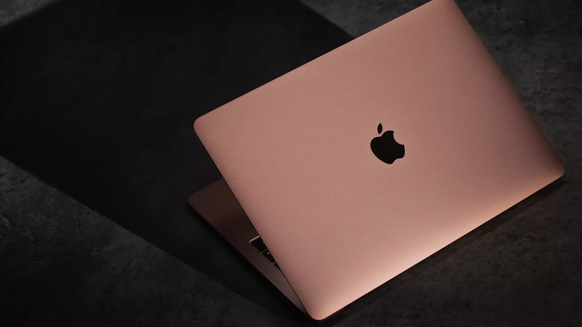 テーブルに置かれたローズゴールドの MacBook Air。