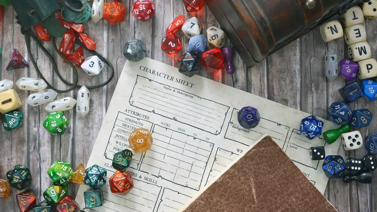 다채로운 RPG 게임 주사위, 캐릭터 시트, 규칙 책, 나무 테이블에 있는 보물 상자를 사용하여 평평한 평판 역할을 하는 탁상 역할
