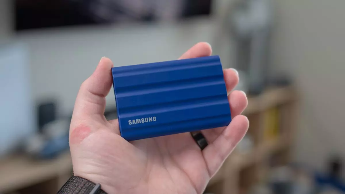 Samsung T7 Shield bærbar SSD holdt i en persons hånd