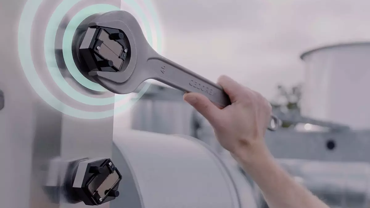Человек, регулирующий новое соединение Smart Screw с помощью гигантского гаечного ключа