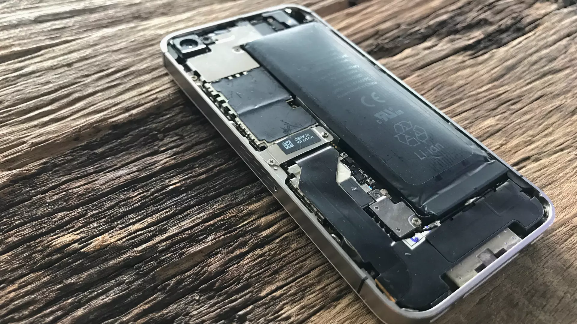 De achterkant van een smartphone met een zichtbaar gezwollen batterij