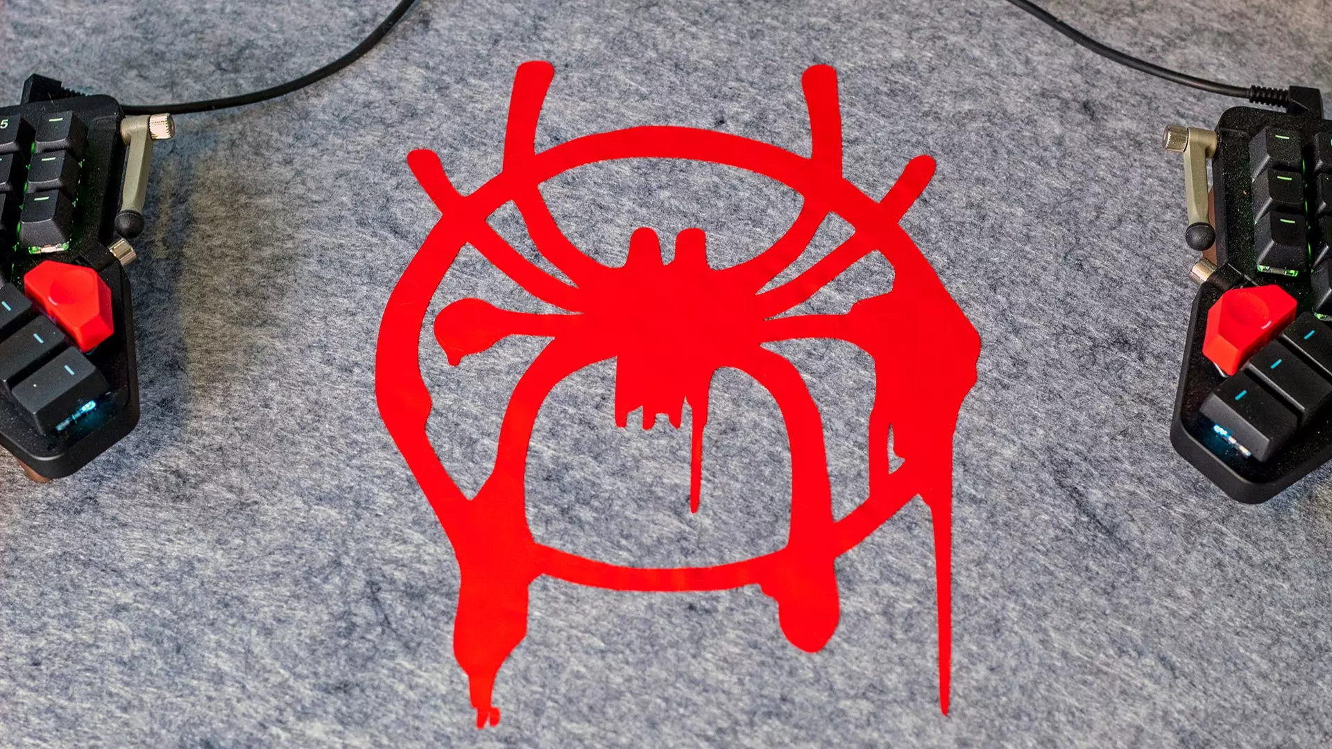 Impresión de vinilo nunha almofada de escritorio que semella un logotipo de Spider-Man pintado con spray