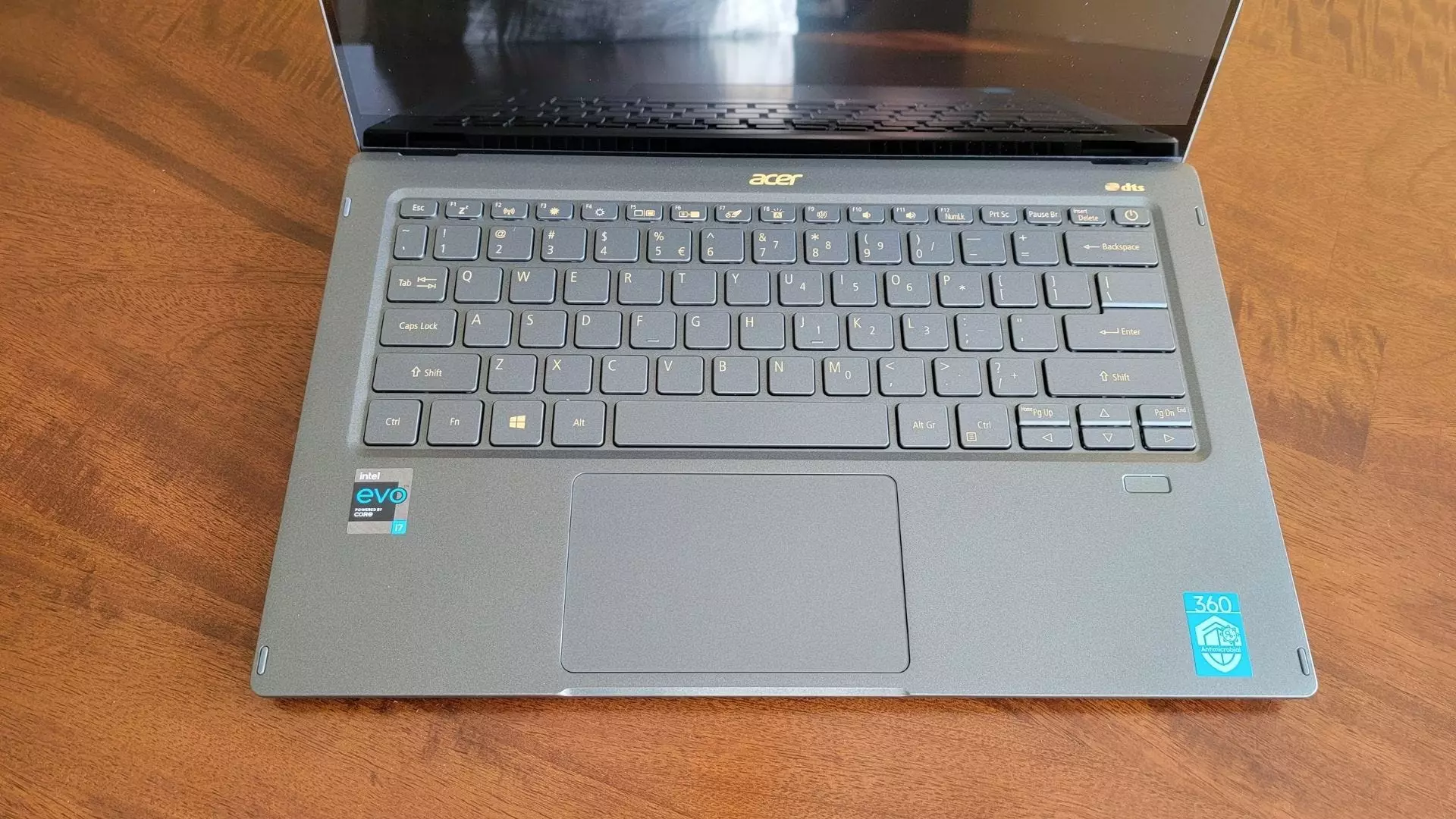 snimak iznad glave laptopa acer swift 5 otvorenog na drvenom stolu, fokusirajući se više na tastaturu