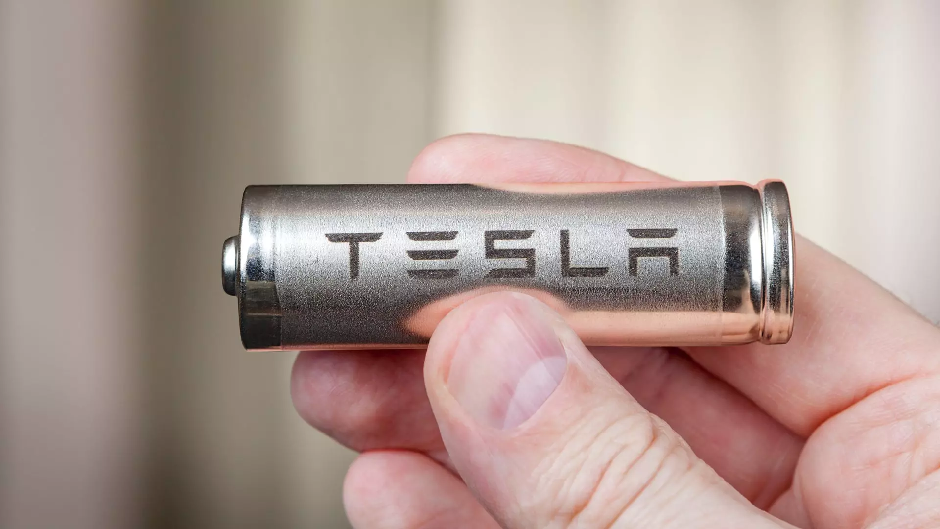 Célula de bateria Tesla em uma mão