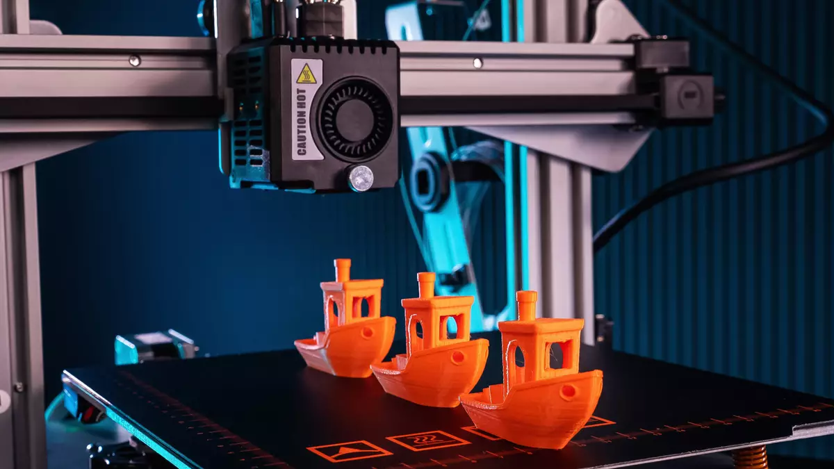 En 3D-skrivare med tre 3D-printade båtar på sin bädd.