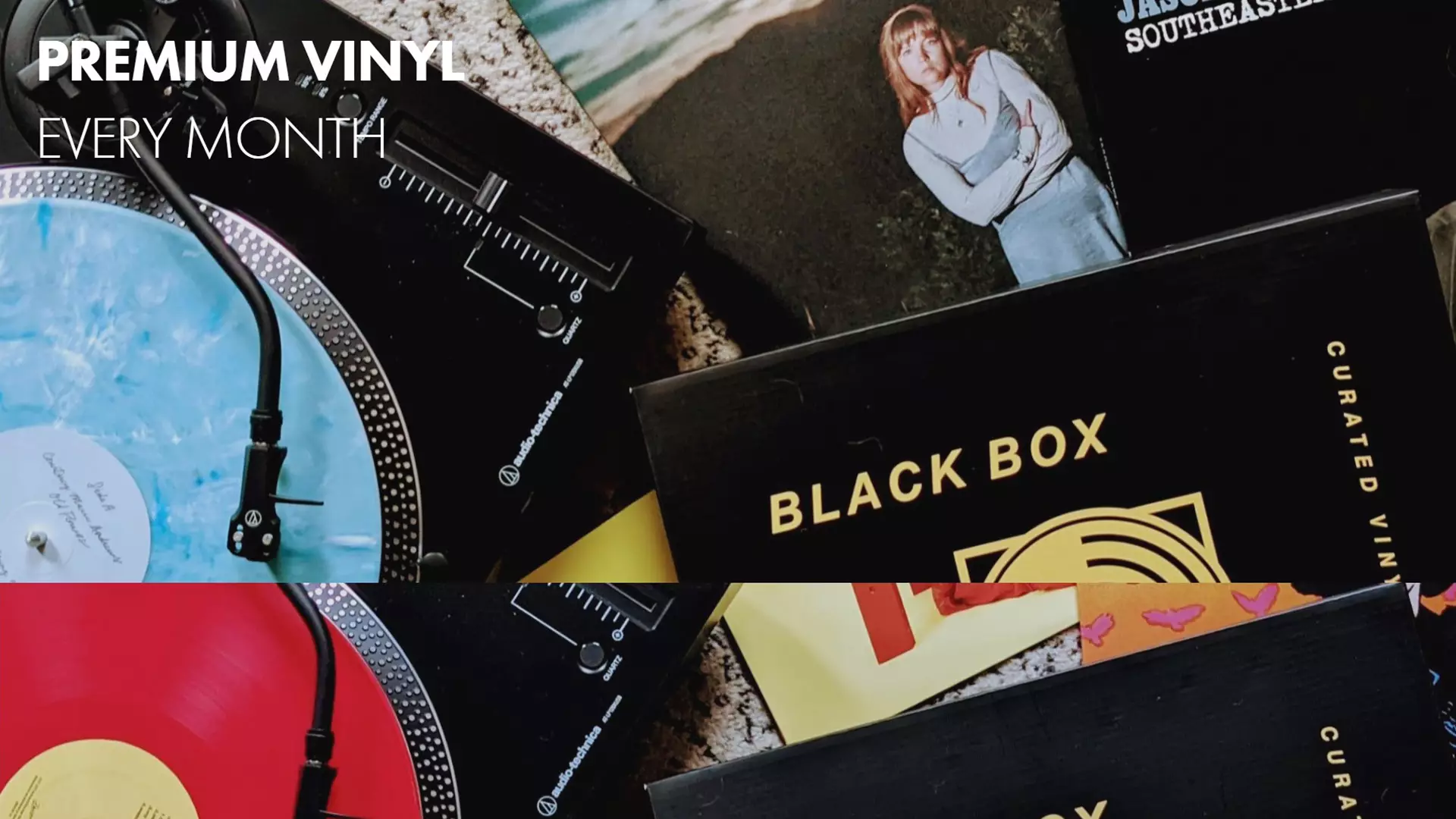 Top-down-billede af vinylplader og Black Box-boks ved siden af pladespiller, der spiller en rød vinyl