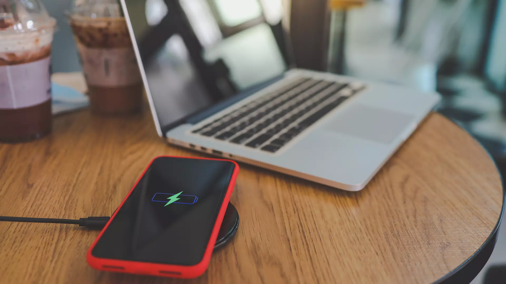 एउटा डेस्कमा आईफोन र म्याकबुक चार्ज गर्दै