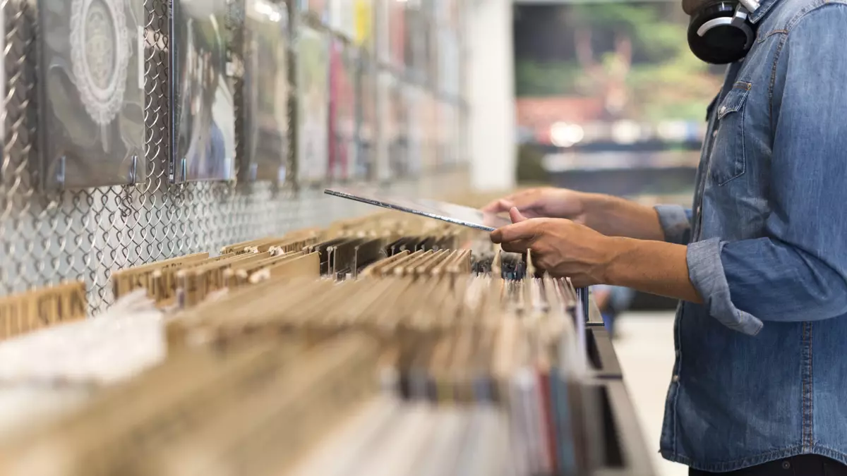 Pessoa navegando em álbuns de vinil em uma loja de discos