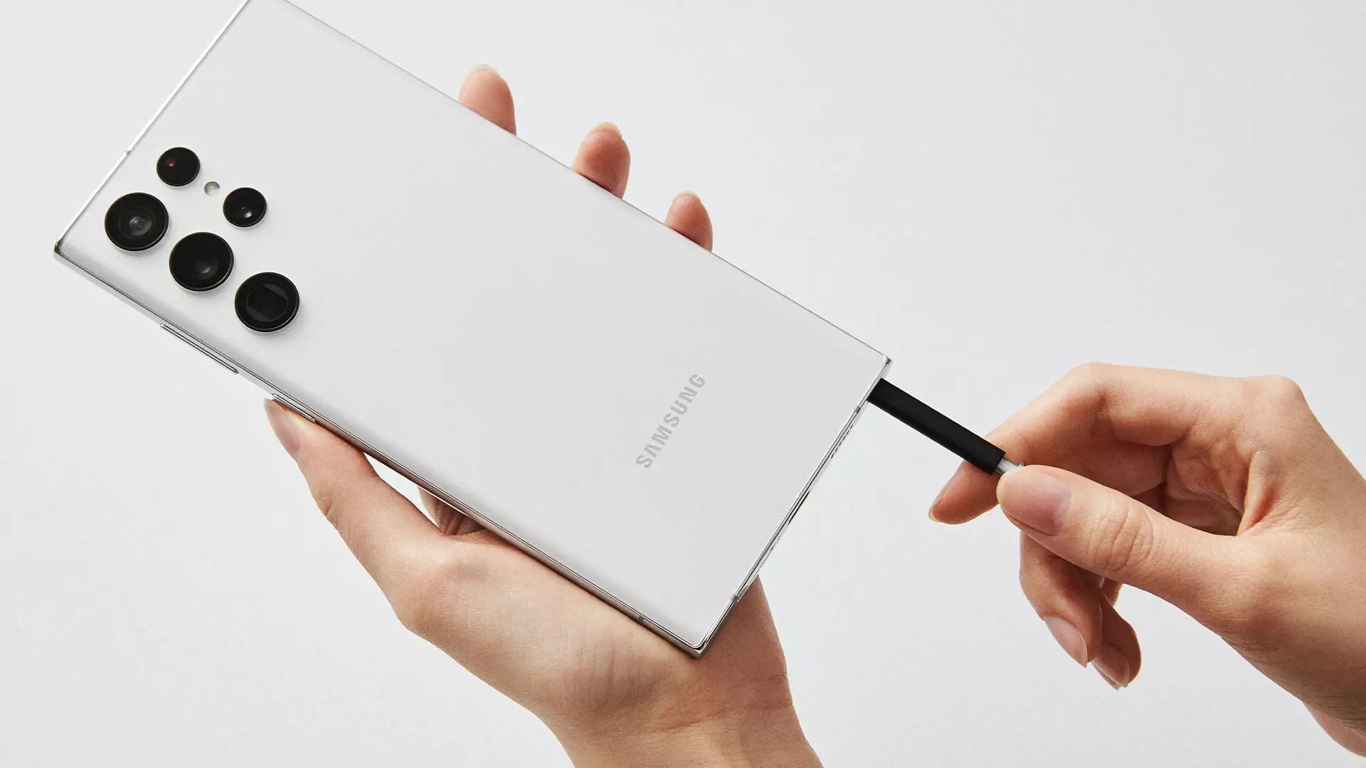 Samsung Galaxy S22 Ultra yenye rangi nyeupe na S Pen yake.
