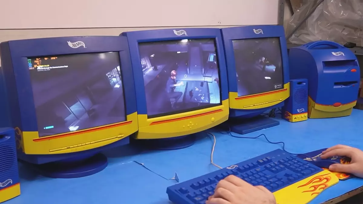 Tres monitores Hot Wheels CRT, una torre, un teclado y parlantes que se usan para jugar