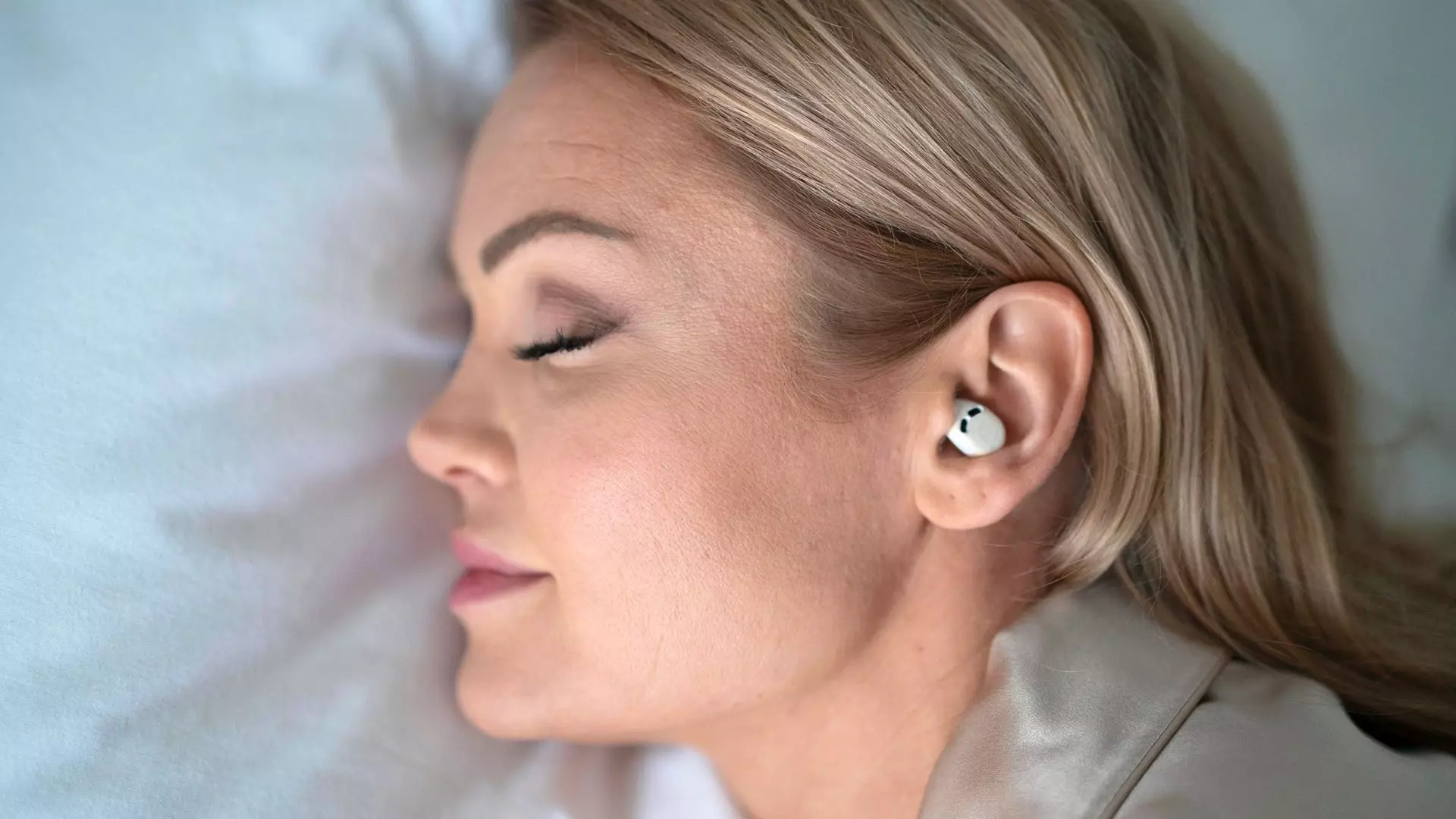 Μια γυναίκα που κοιμάται ενώ ακούει αληθινά ασύρματα ακουστικά
