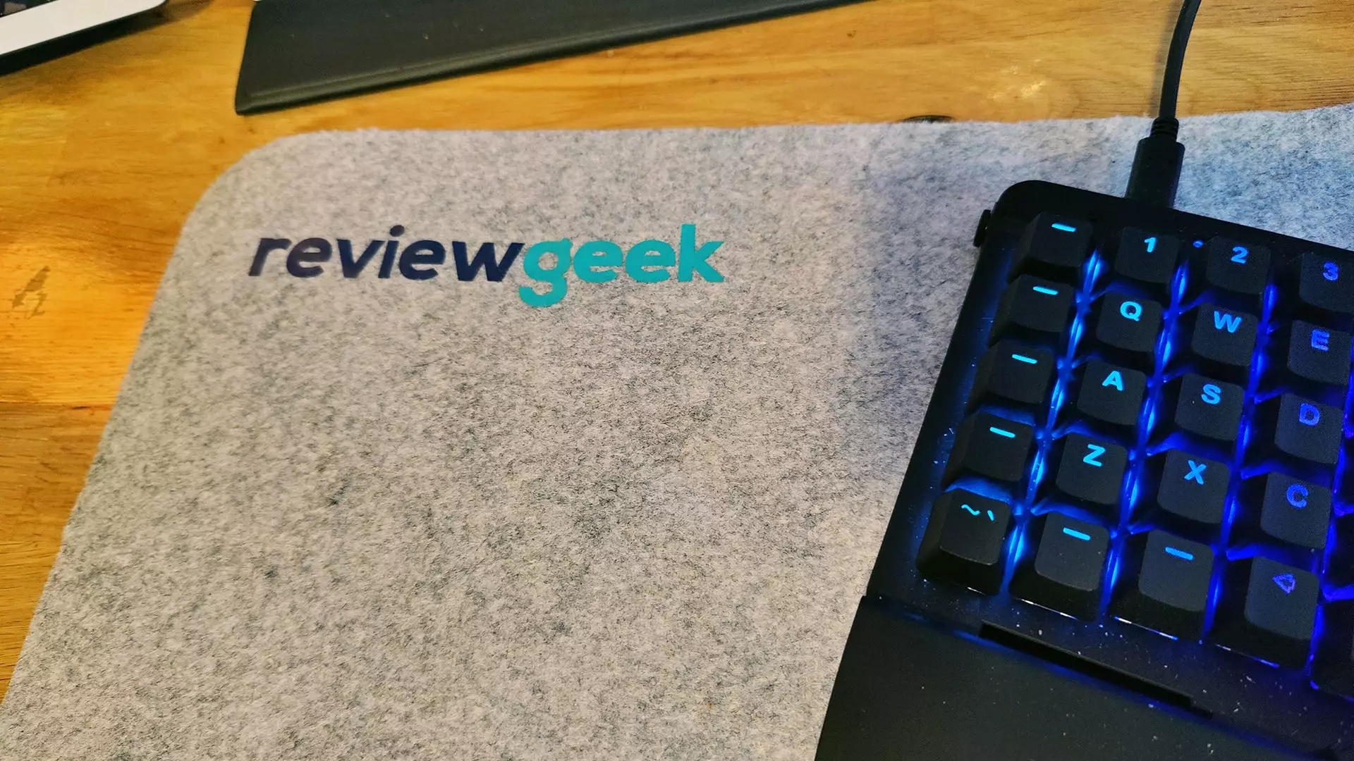 Подложка за мишка за бюро от филц с надпис Review Geek върху нея