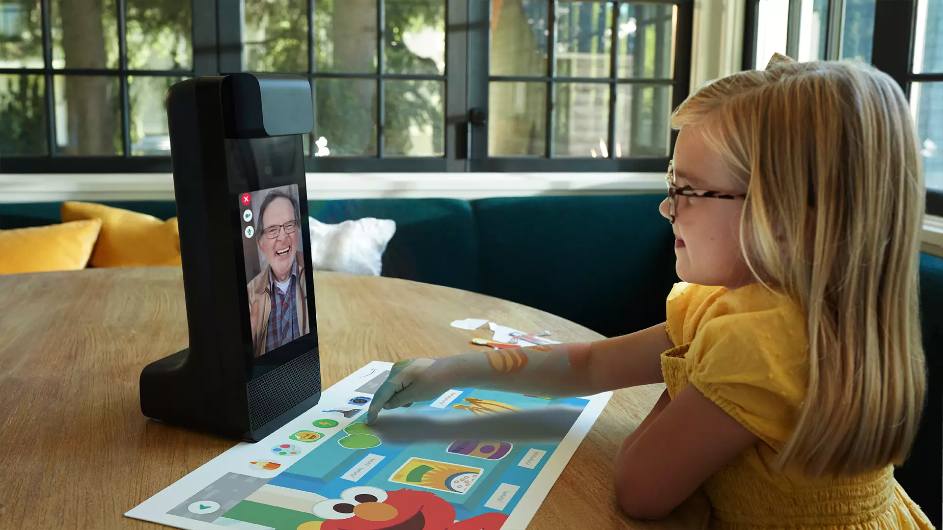 Lapsi, joka pelaa Amazon Glow'ta Elmo-pelin kanssa projisoituna pöydälle.