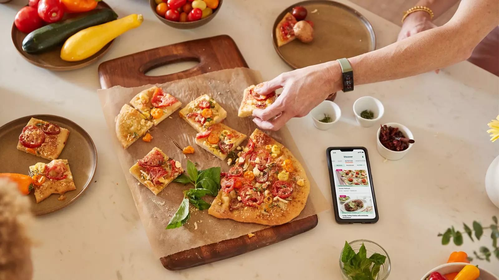 Halo Nutrition App offen in der Küche neben Gemüse und Fladenbrot