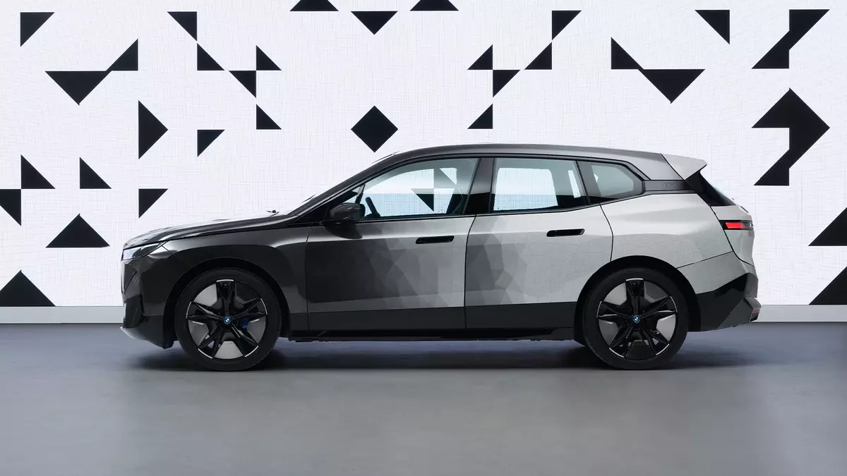 BMW iX Flow 概念车。一辆汽车正在从黑色油漆工作过渡到白色油漆工作。