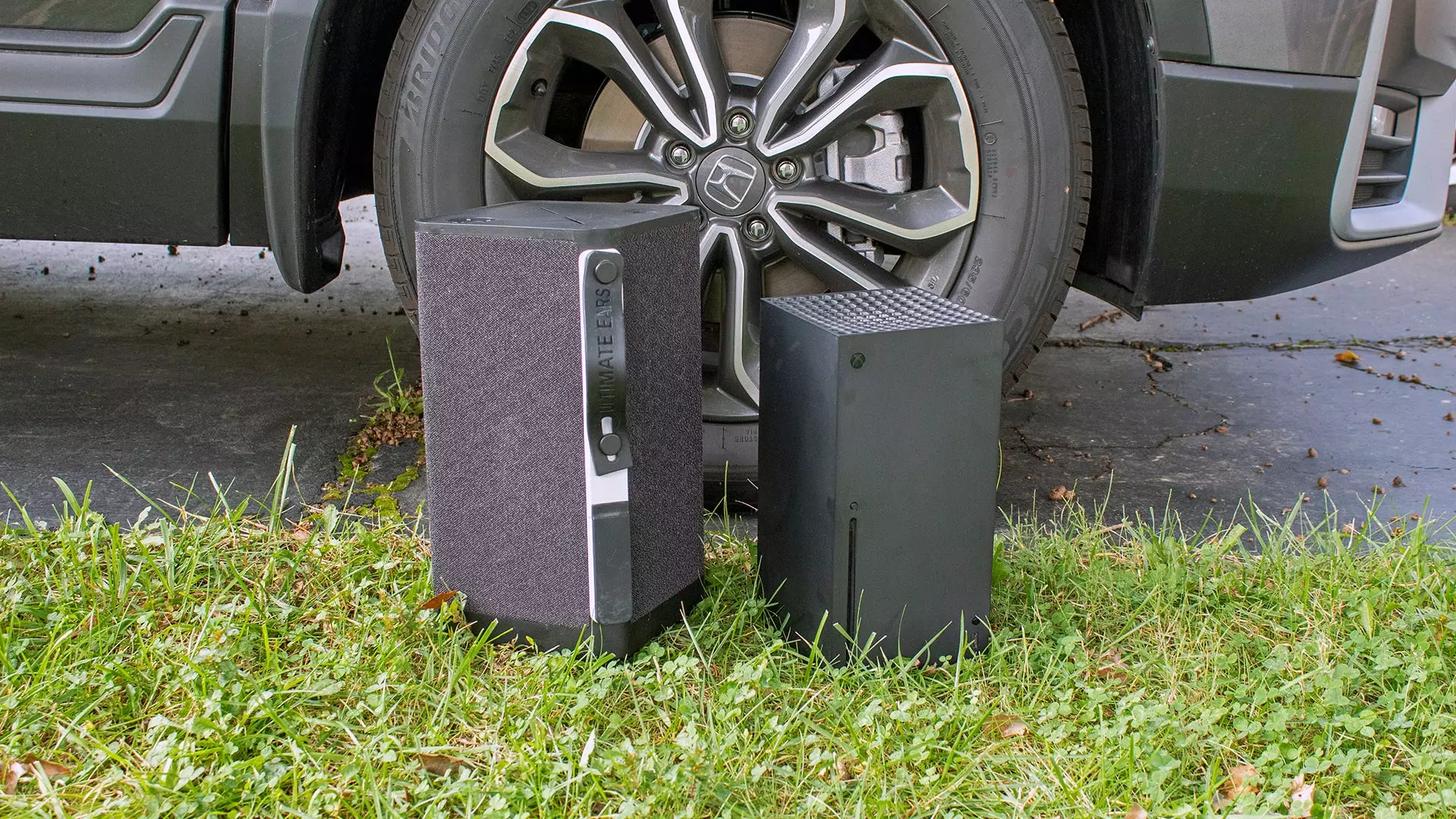 Isang malaking portable speaker sa tabi ng isang mas maliit na Xbox Series X
