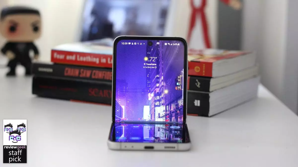 De Galaxy Z Flip 3 geopend op een bureau, boeken op de achtergrond