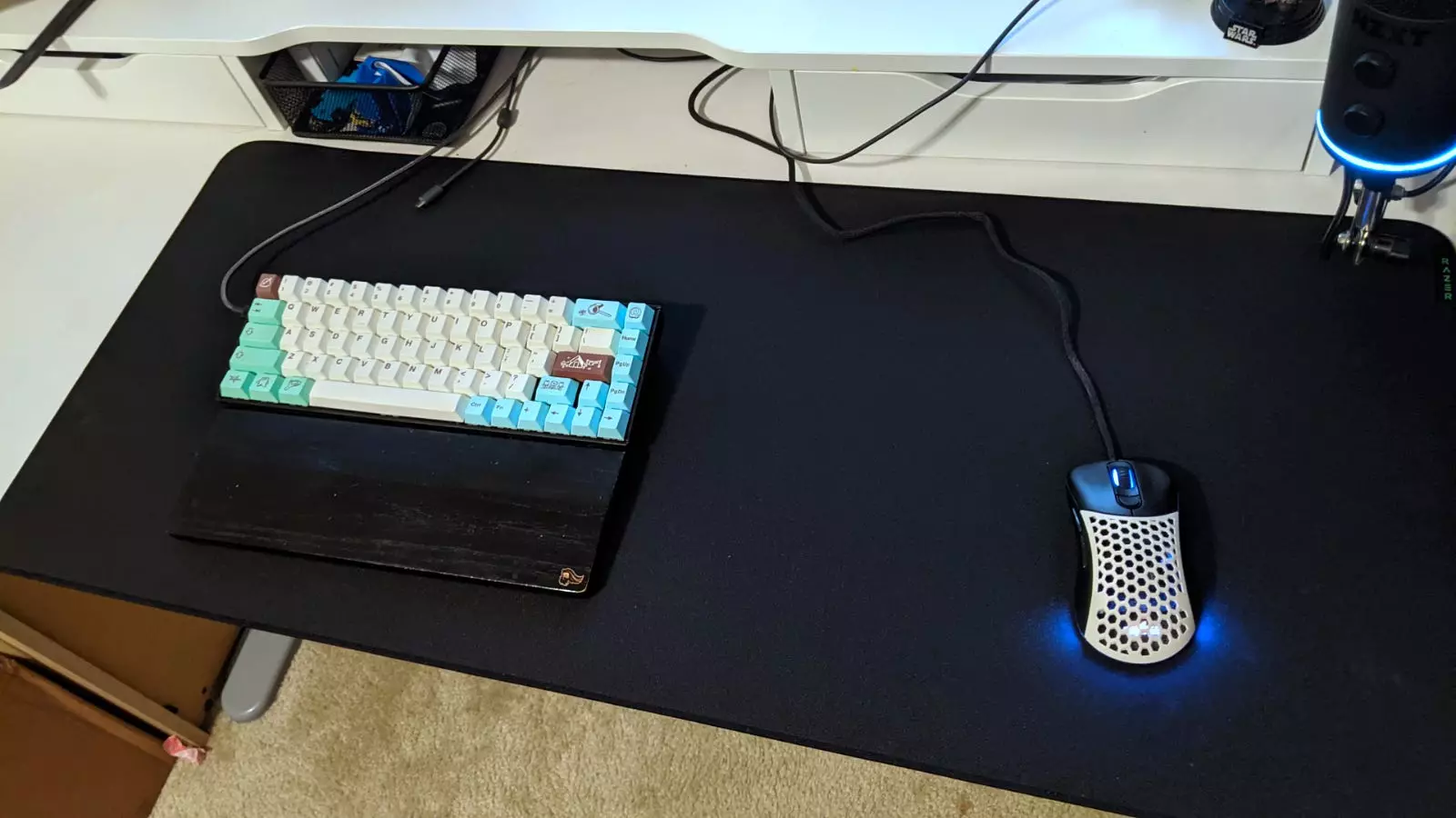 कीबोर्ड और माउस के साथ डेस्क पर XXL ब्लैक रेजर स्ट्राइडर माउसपैड।