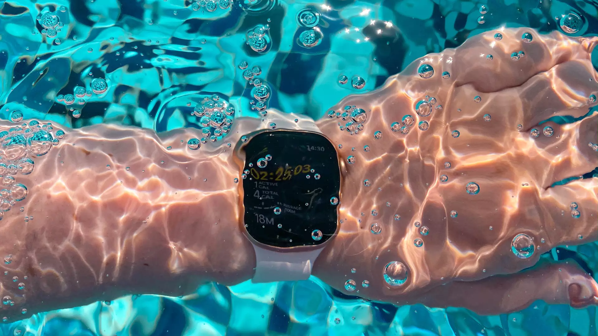 Ujumisbasseinis veealune roosa spordirihmaga Apple Watchi lähivõte ja spordirakendus ekraanil