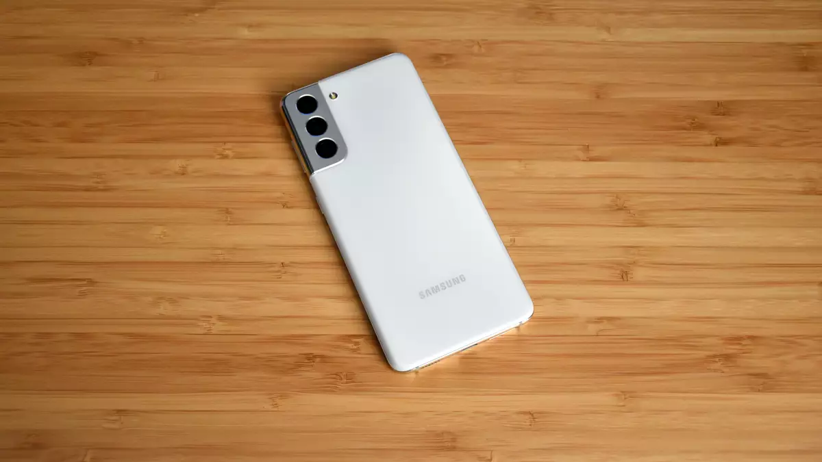 Samsung Galaxy S21 рӯ ба рӯи мизи чӯбин аст