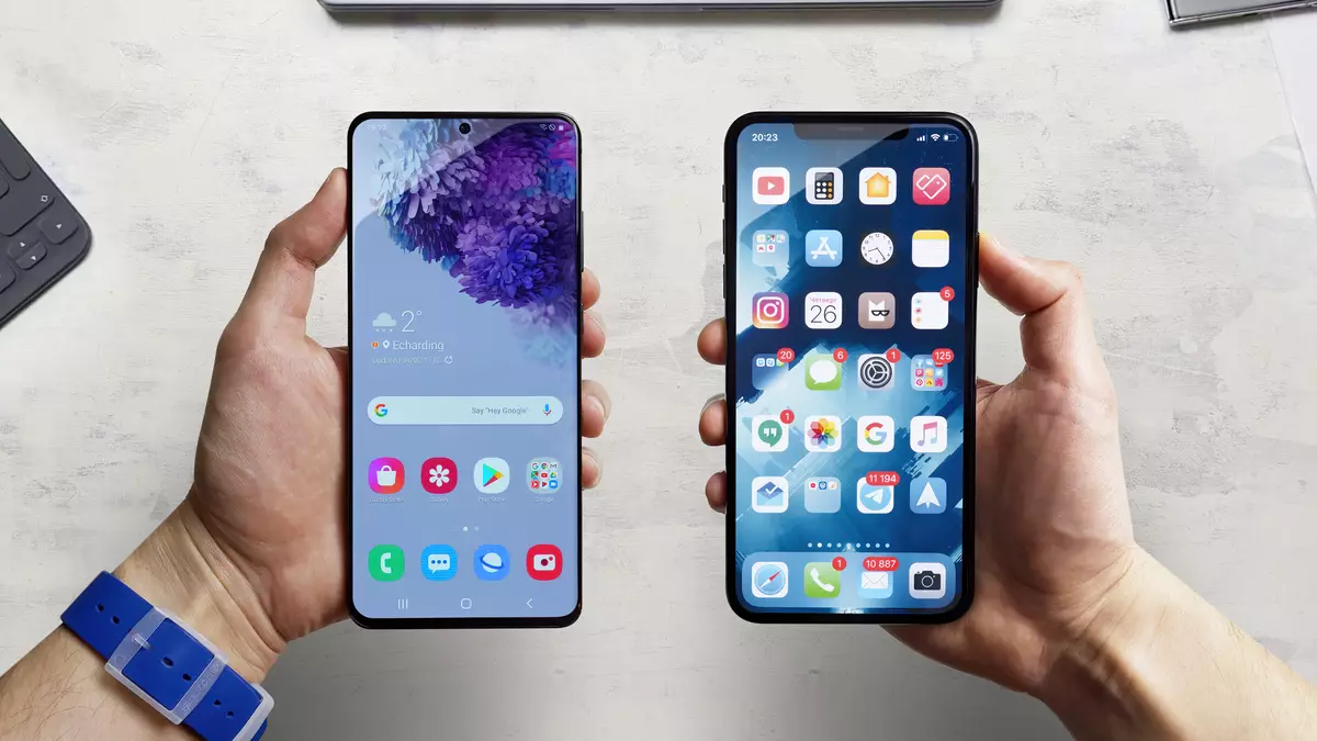 Un smartphone Samsung cu Android și un iPhone Apple unul lângă celălalt, cu afișajele pornite și deblocate