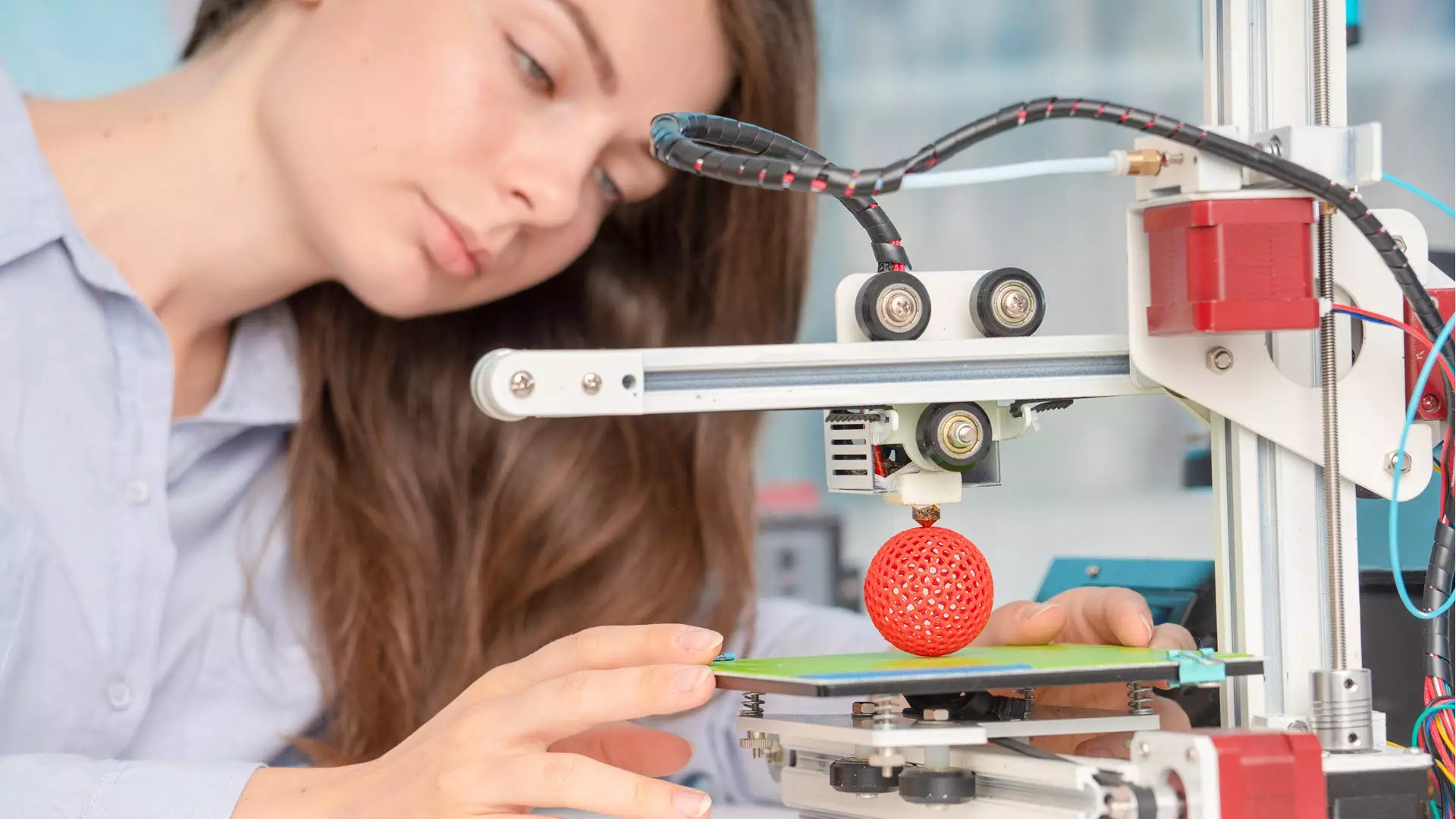 Žena při pohledu na 3D tisk v procesu.
