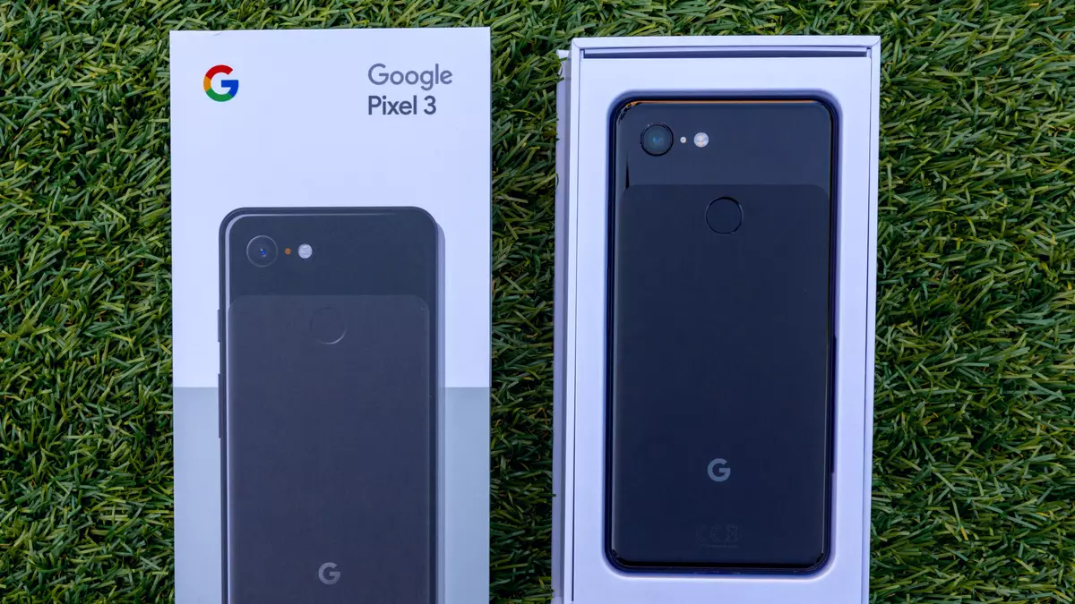 Google Pixel 3 i æske udgivet af google et alfabetfirma i 2019. Billedet viser den seneste mobiltelefon i sin æske på en grøn græsbaggrund.