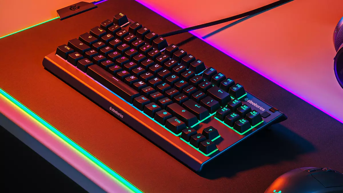 D'SteelSeries Apex 3 mechanesch Tastatur bei engem Schreifdësch. Et ass kabellos, tenkeyless, an huet RGB Géigeliicht.