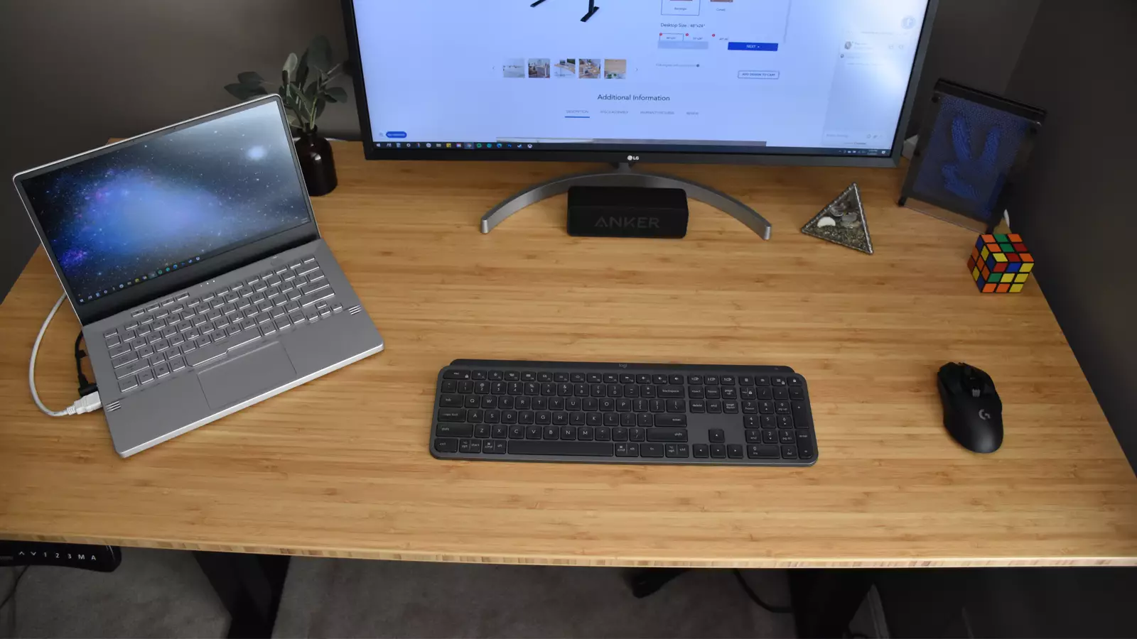 Blick auf den Schreibtisch mit Laptop, Monitor, Tastatur, Maus und anderen Schmuckstücken darauf