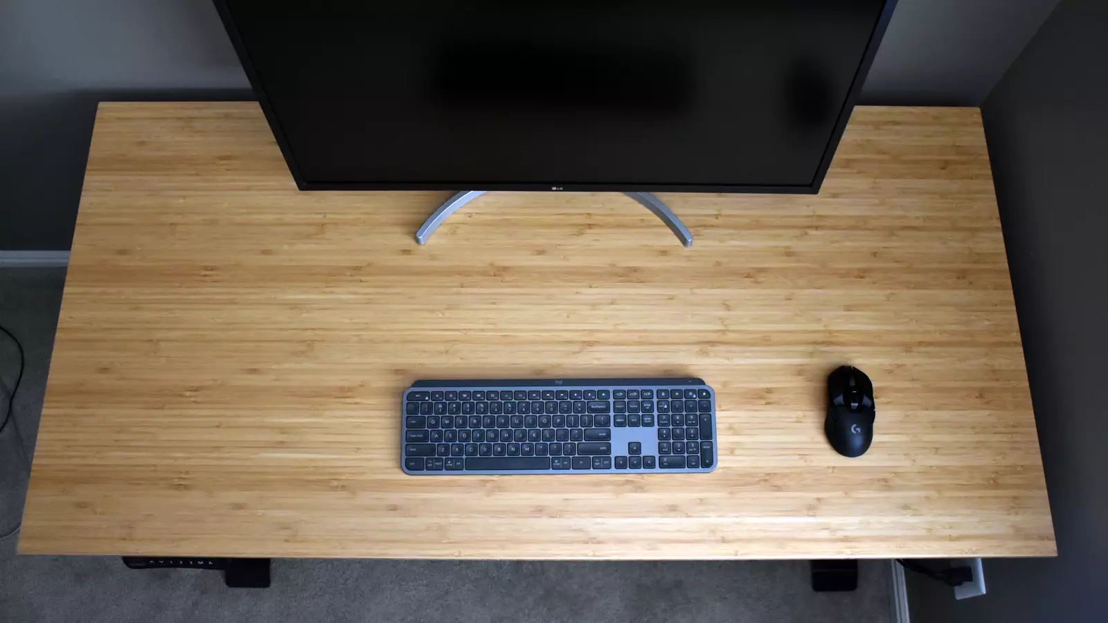 Draufsicht auf den Schreibtisch mit nur einer Tastatur, einem Monitor und einer Maus darauf