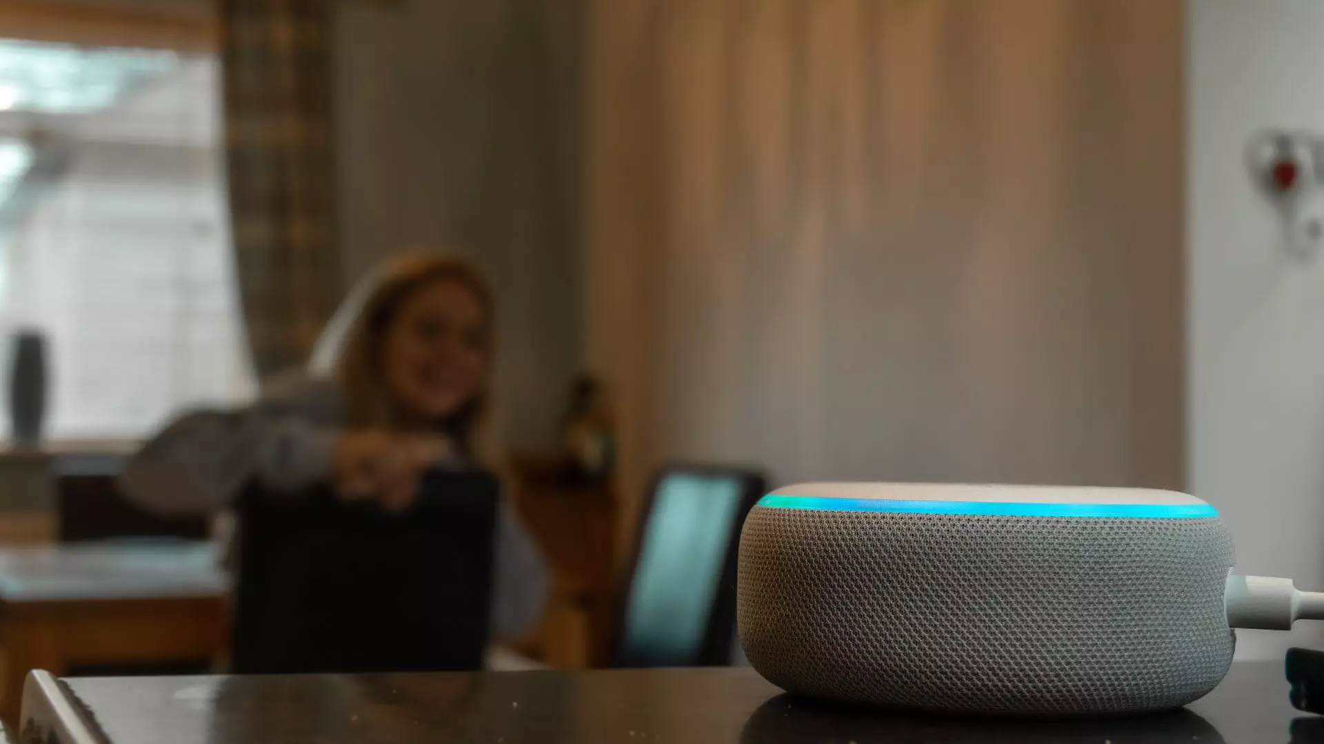 Egy nő egy Amazon Echo ponthoz beszél, miközben homlokát ráncolva.