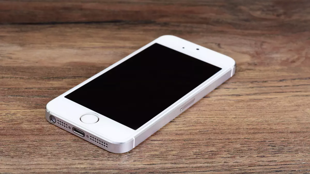 Apple iPhone 5 em branco sobre uma superfície de madeira