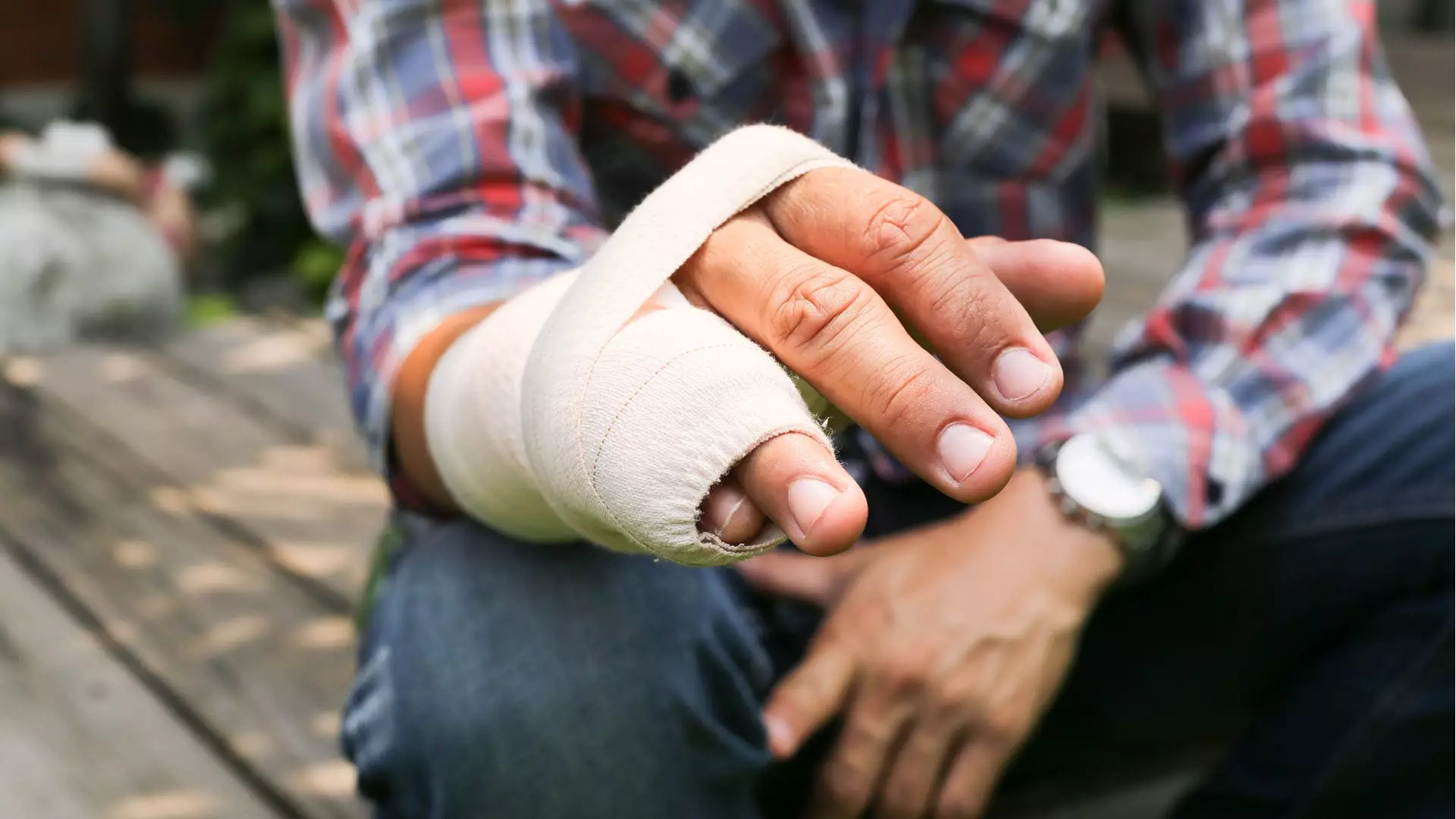 一个男人，他的无名指和小指被石膏包裹着。