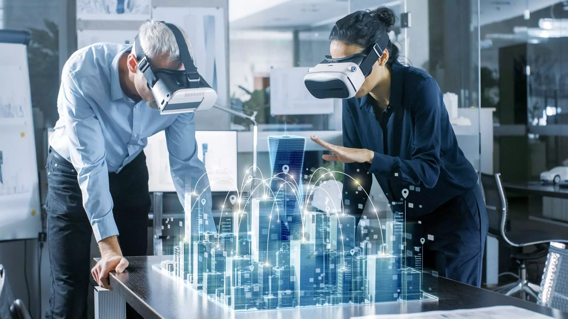 VR 场景中的两个人盯着一座城市的虚拟建筑示意图。