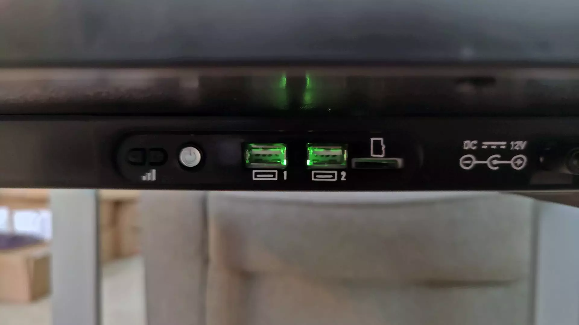 Barošanas poga blakus USB portiem un SD kartes slots.